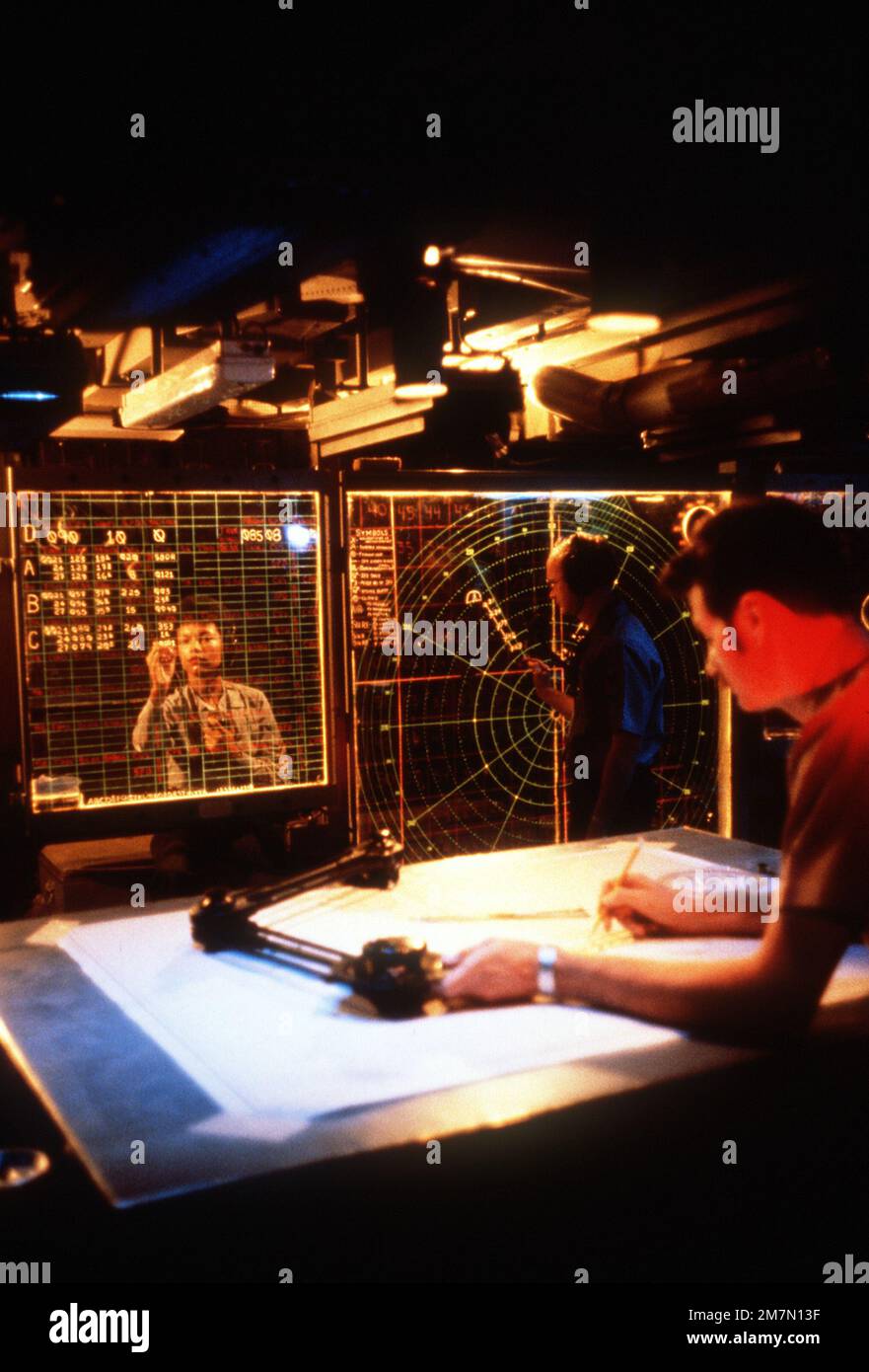 A crewman plots a chart in the Combat Information Center (CIC) of a ...