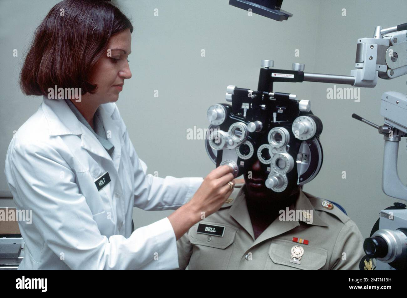 A female U.S. Army optometrist conducts a vision test. Country: Unknown ...