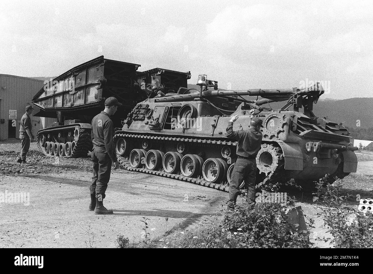 A right side view of an M-88 armored recovery vehicle towing an Armored ...