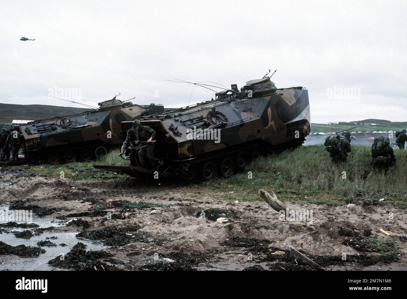 Combat-ready Marines debark from two LVTP-7 tracked landing vehicles on ...