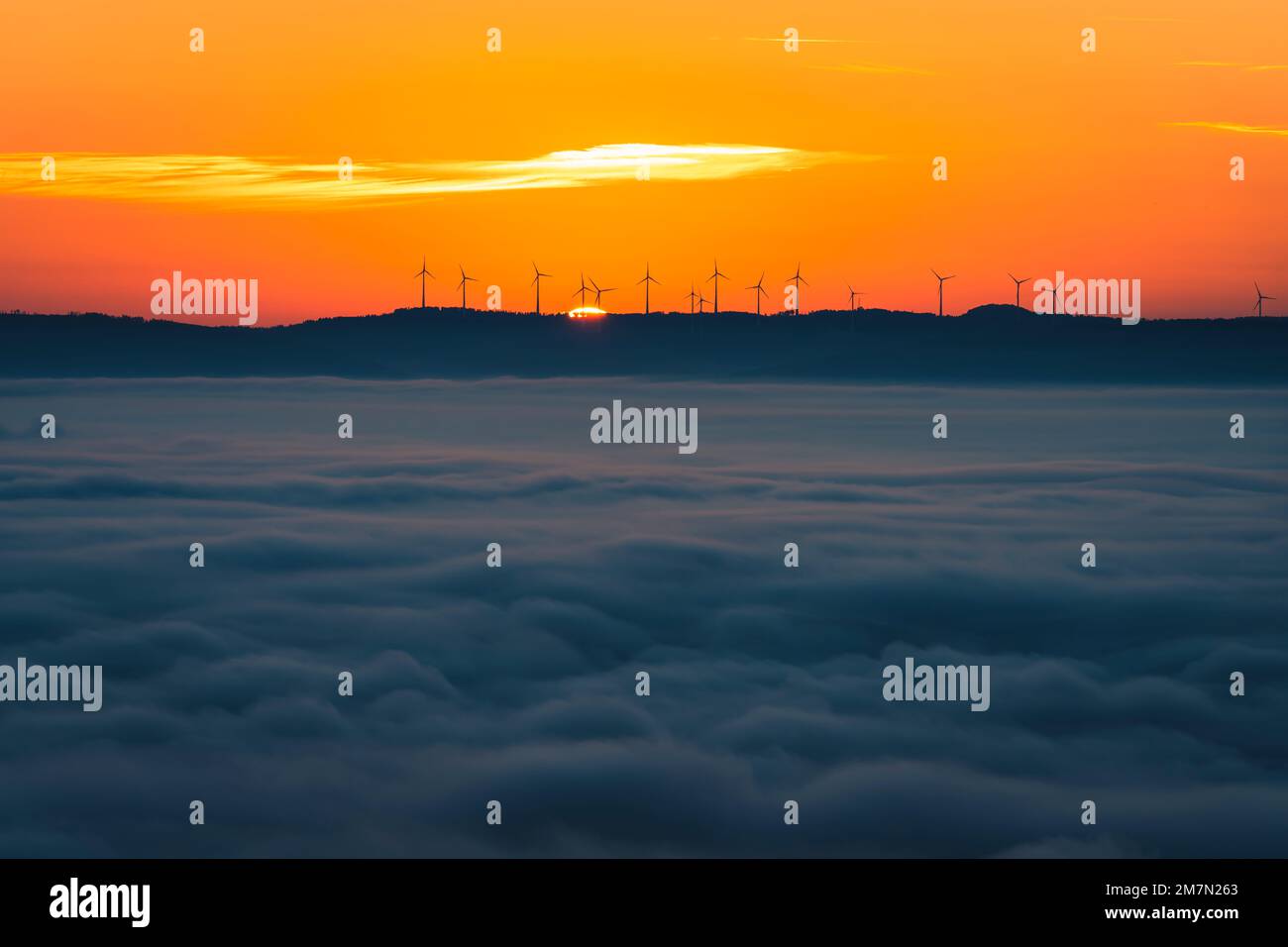 Wind turbines silhouetted on the horizon near Kassel, morning red in ...