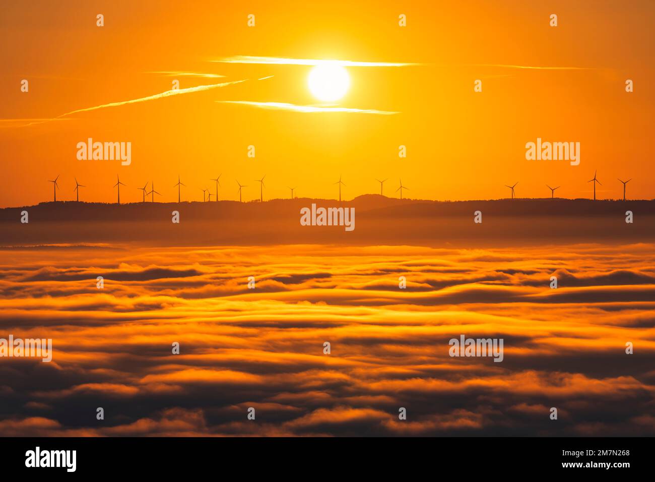 Wind turbines silhouetted on the horizon near Kassel, morning red in ...