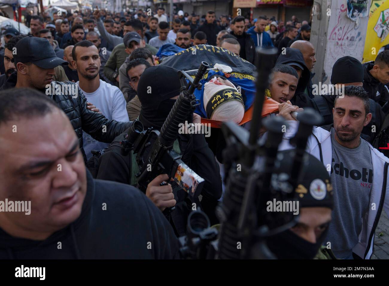 Mourners carry the body of Tarek al-Damj during his funeral in the West ...