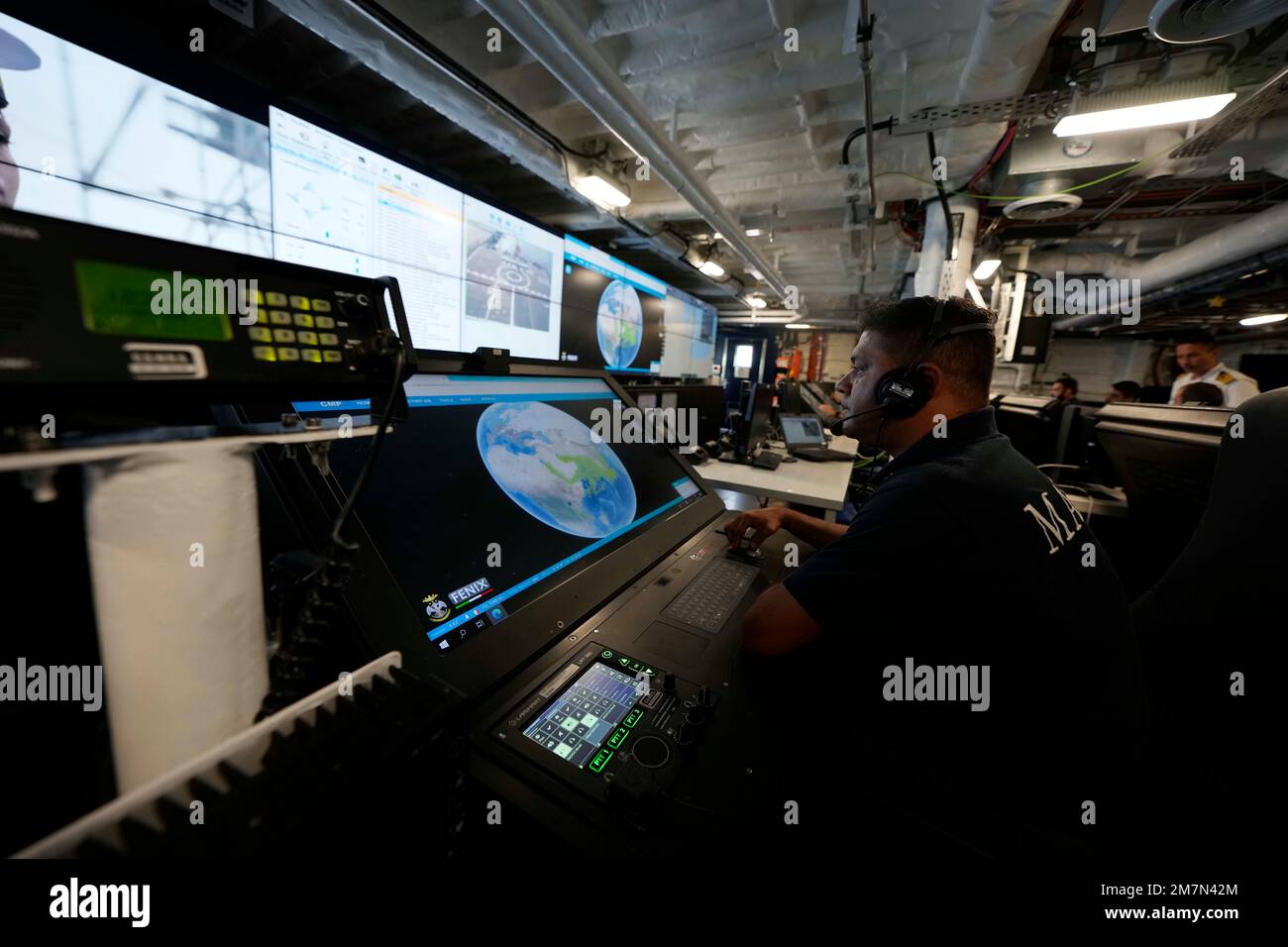 Italian Navy crew members work at the command cockpit station inside ...