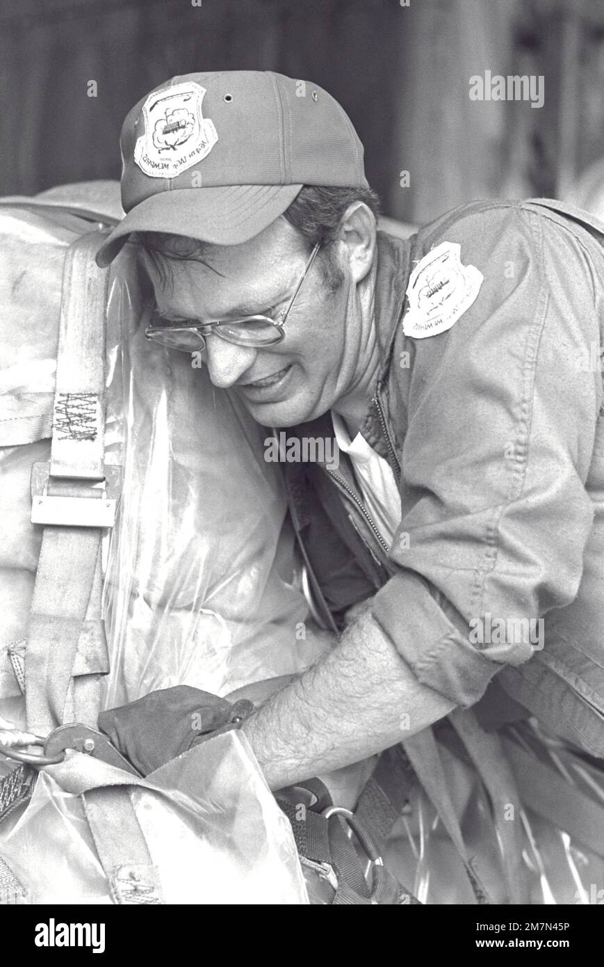 Technical Sergeant Robert G. Mynatt pushes a pallet of cargo into place ...