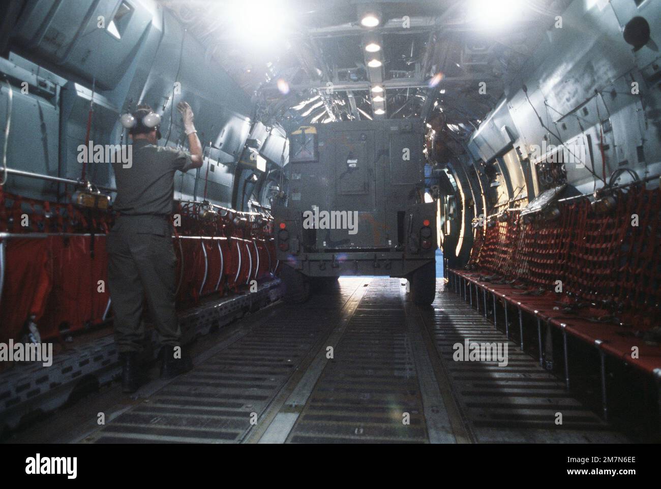 A member of the 619th Military Airlift Support Squadron guides a US ...
