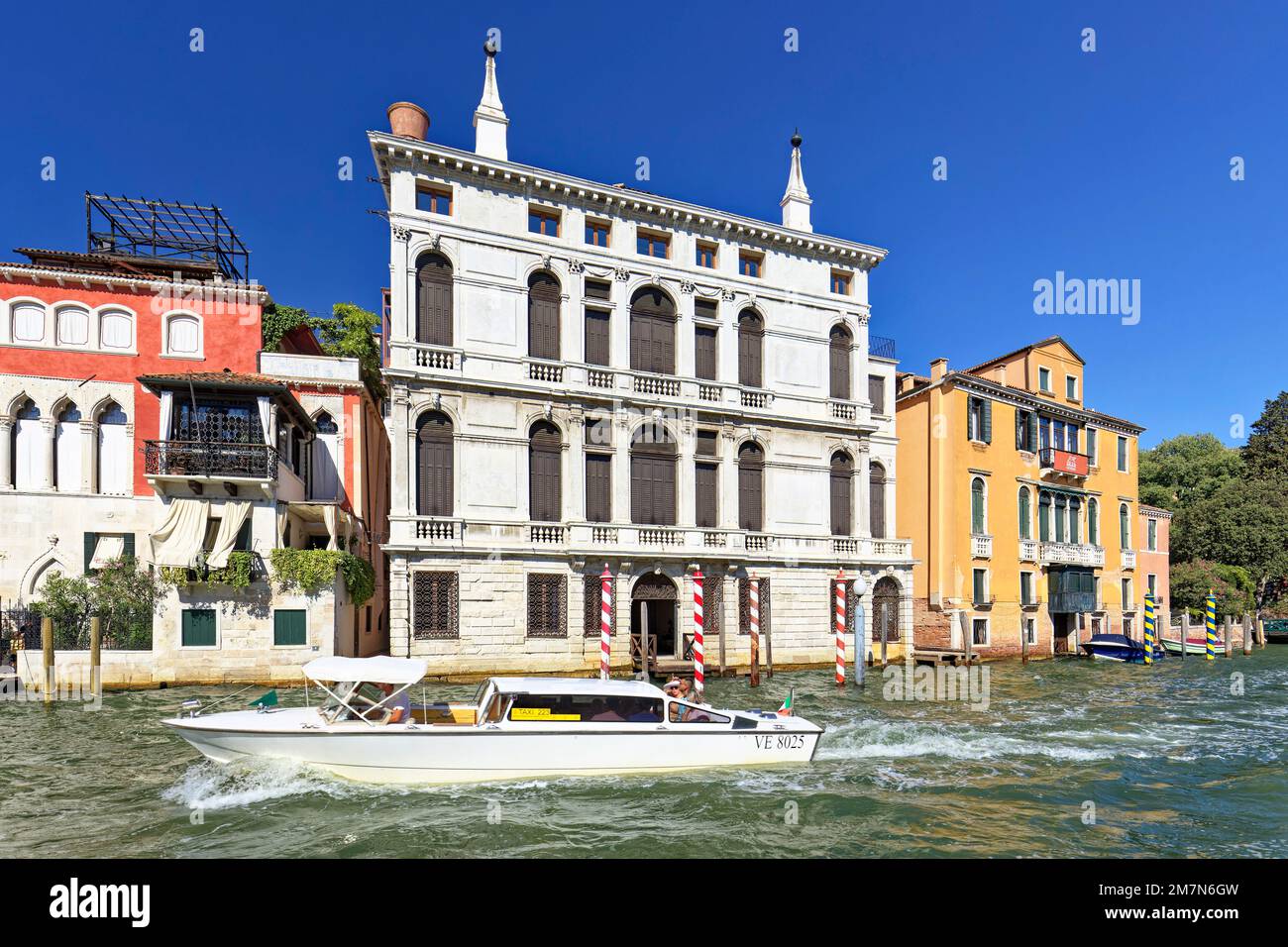 A motorboat passes magnificent houses on the Grand Canal in Venice ...