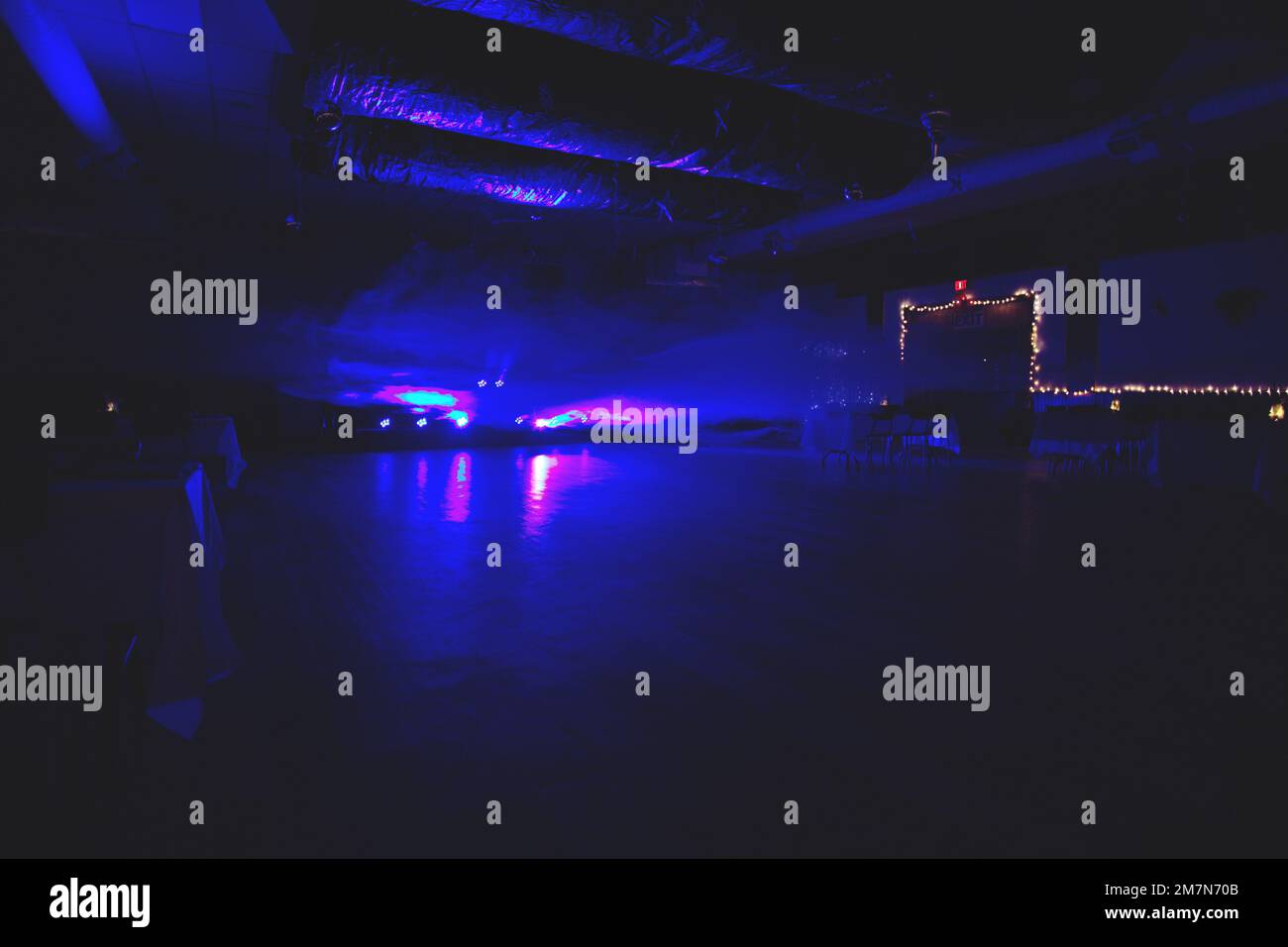 A dark empty venue with decorated tables and lights Stock Photo - Alamy