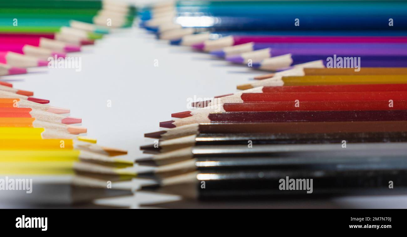 An image of colorful pencils lined up face to face on the white ...