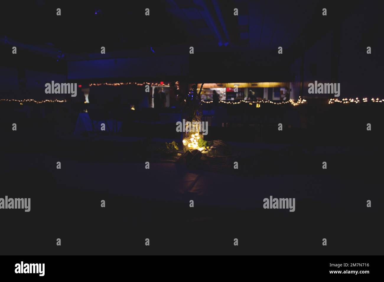 A dark empty venue with decorated tables and lights Stock Photo - Alamy