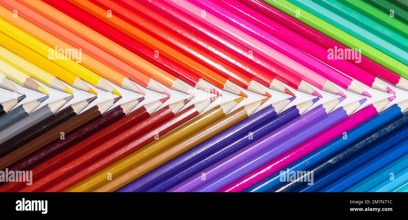 An image of colorful pencils lined up face to face on the white ...