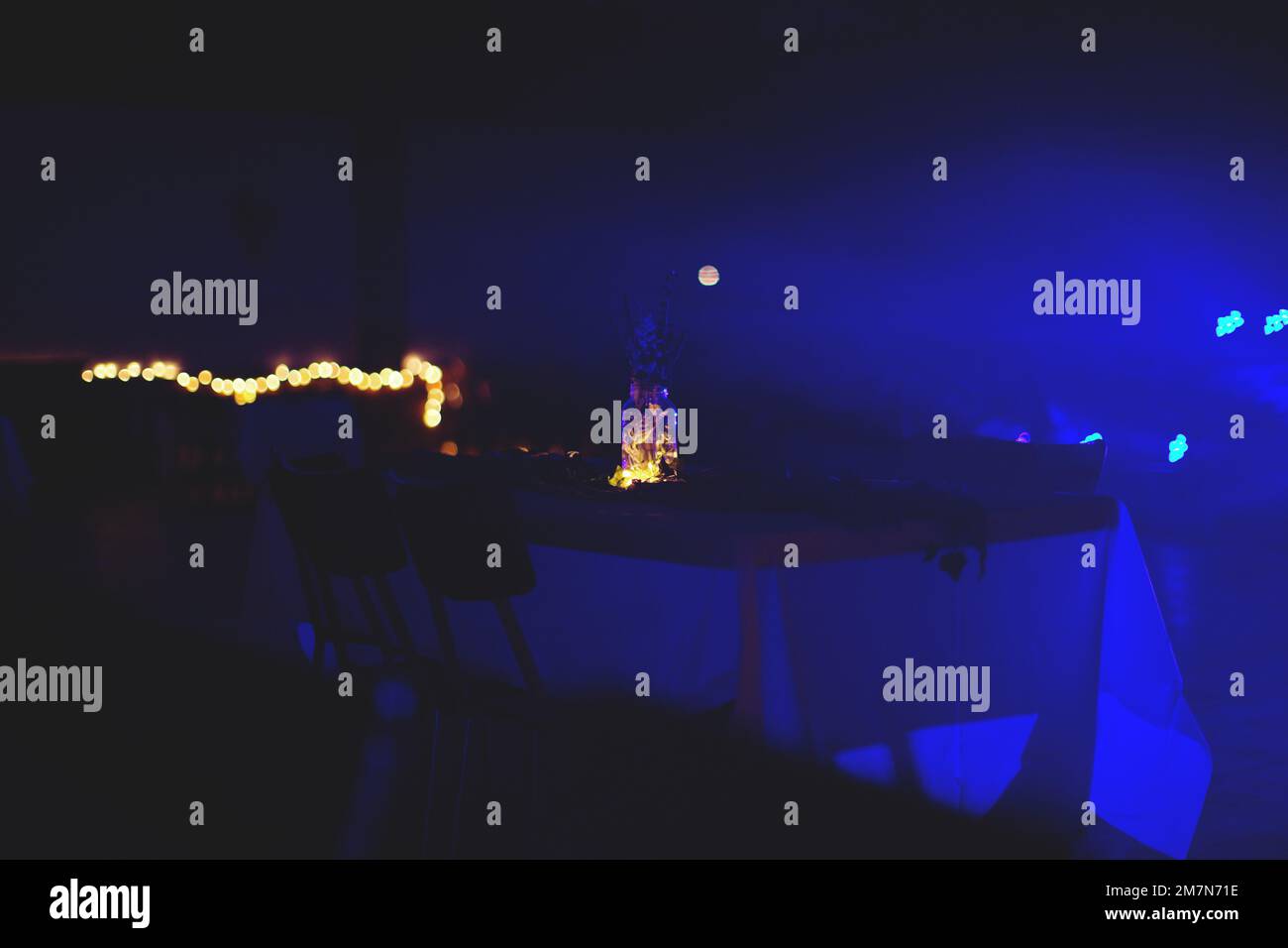 A dark empty venue with decorated tables and lights Stock Photo - Alamy