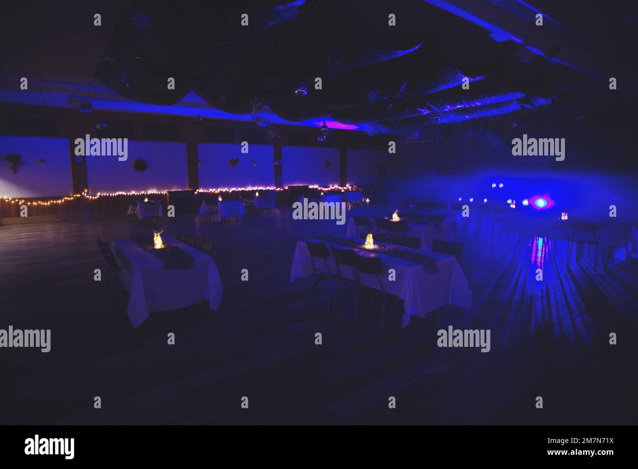 A dark empty venue with decorated tables and lights Stock Photo - Alamy