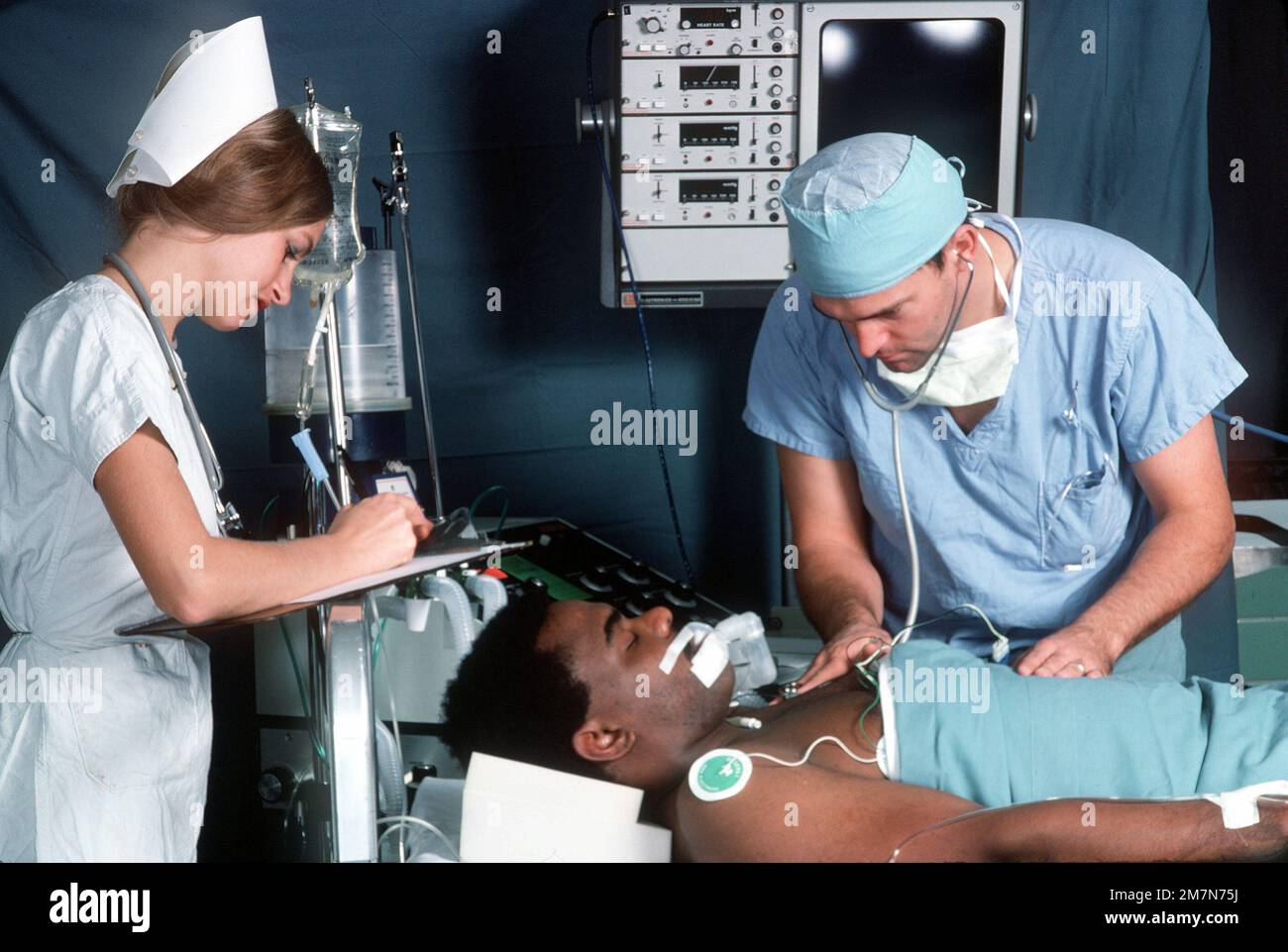 A U.S. Army doctor examines a patient as a nurse takes notes. Country ...