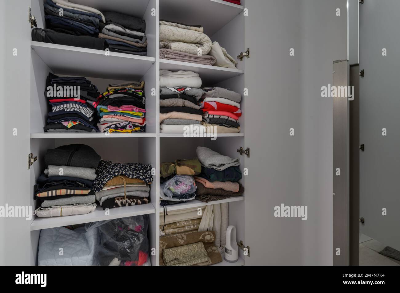 Wardrobe with different clothes at shelves Stock Photo - Alamy