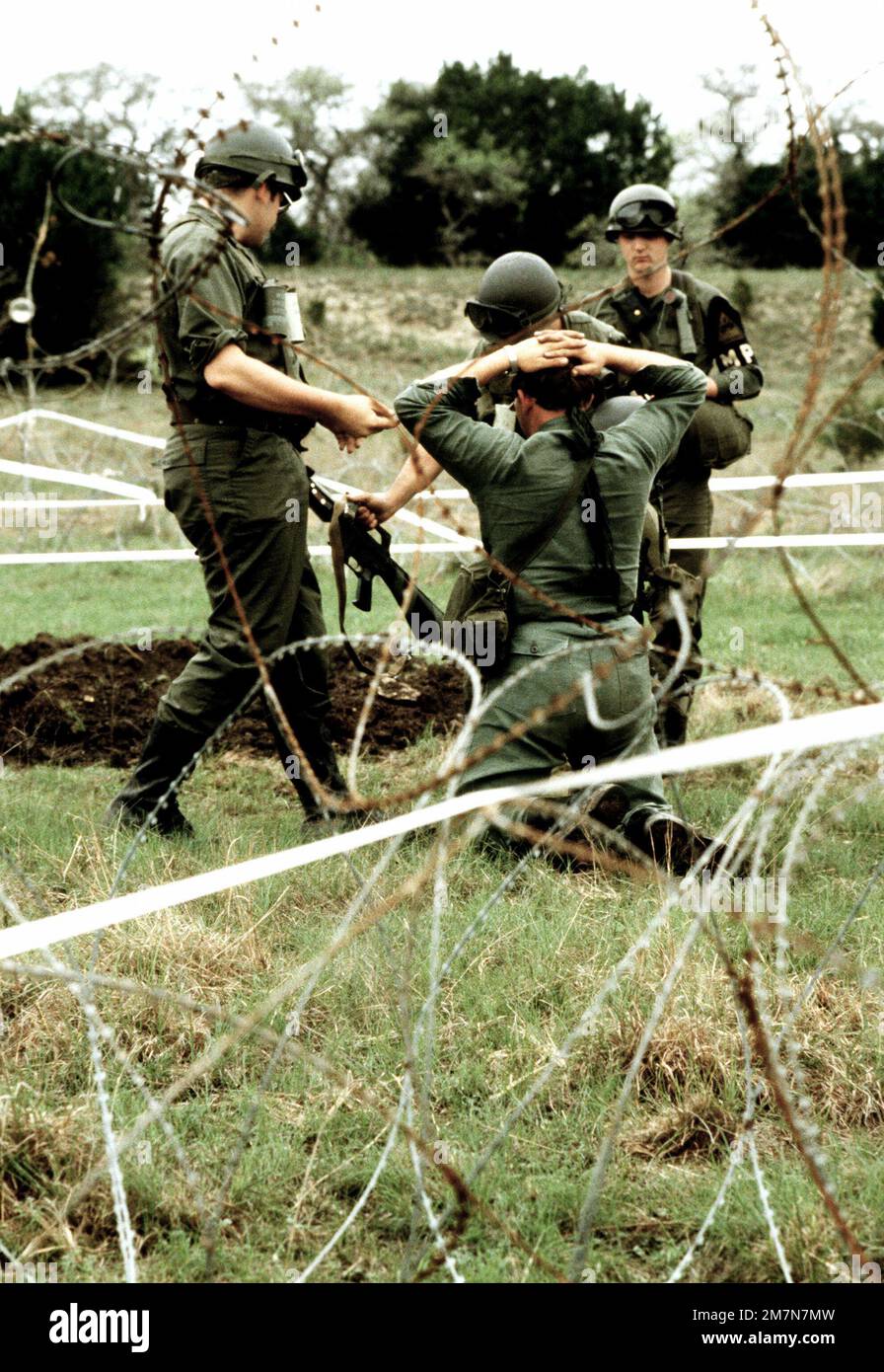 Members of the 502nd Military Police check a "prisoner of war" for ...