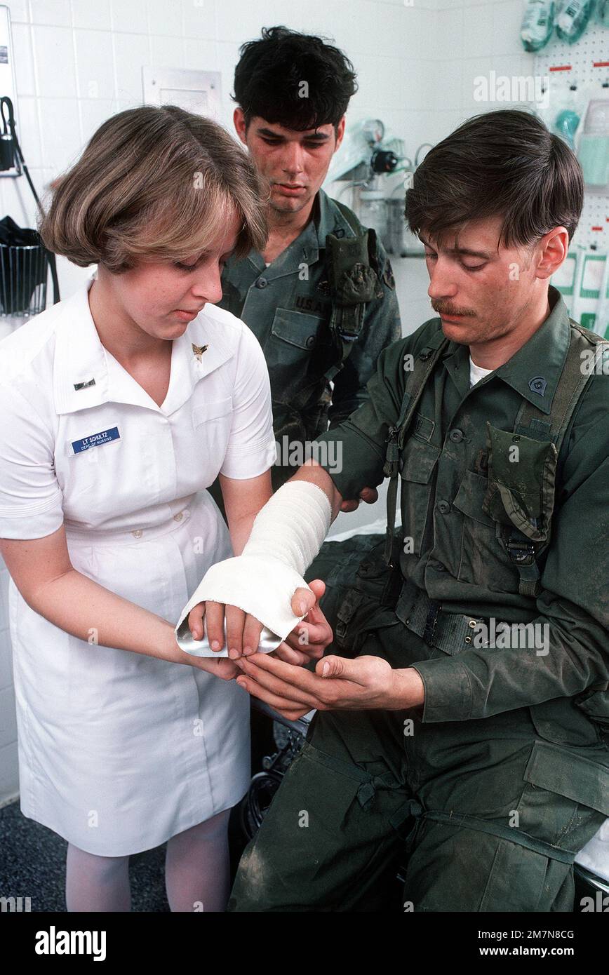 A U.S. Army nurse bandages a soldier's arm. Country: Unknown Stock ...