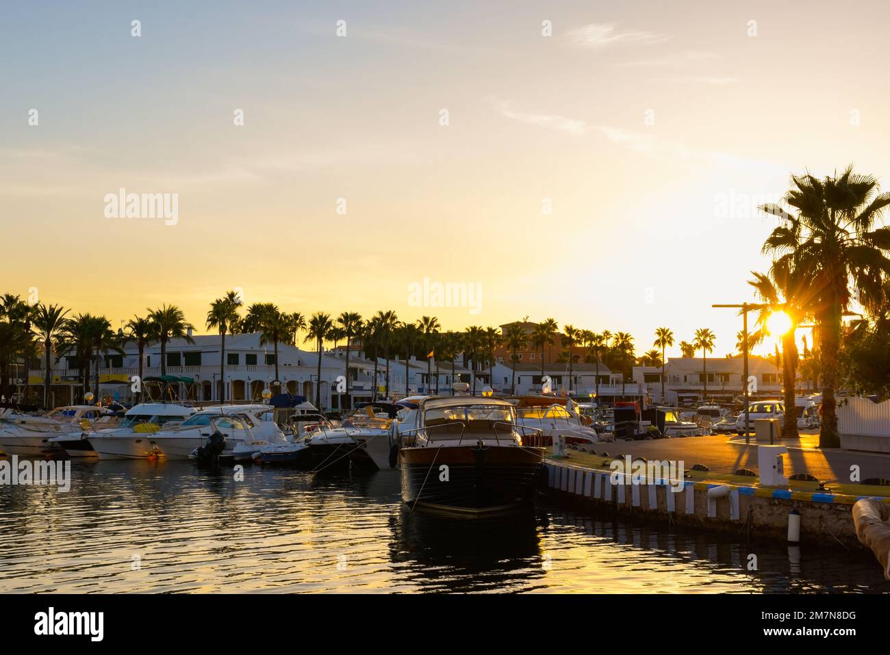 Beautiful sunrise over calm sea water at a tropical marina with luxury ...