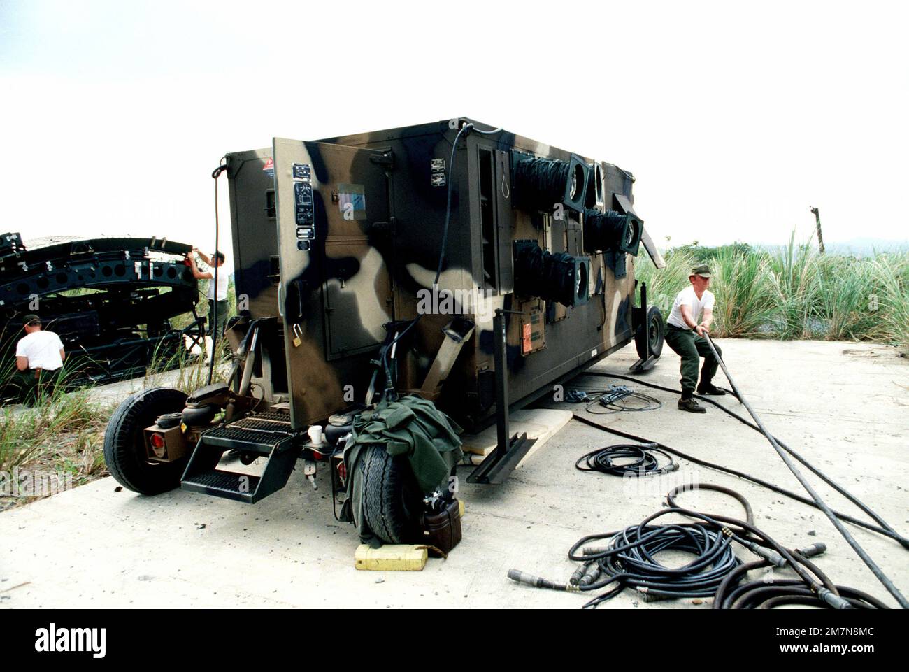 An airman connects power cables to an AN/TPS-43E radar van atop Cerro ...