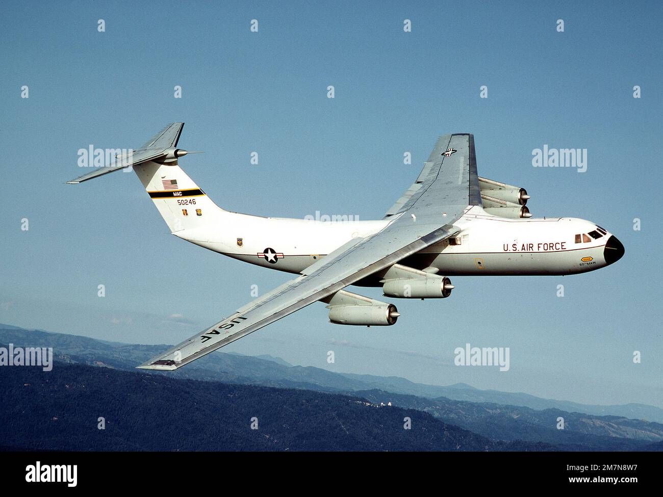 An air-to-air right side view of a C-141 Starlifter aircraft from the ...