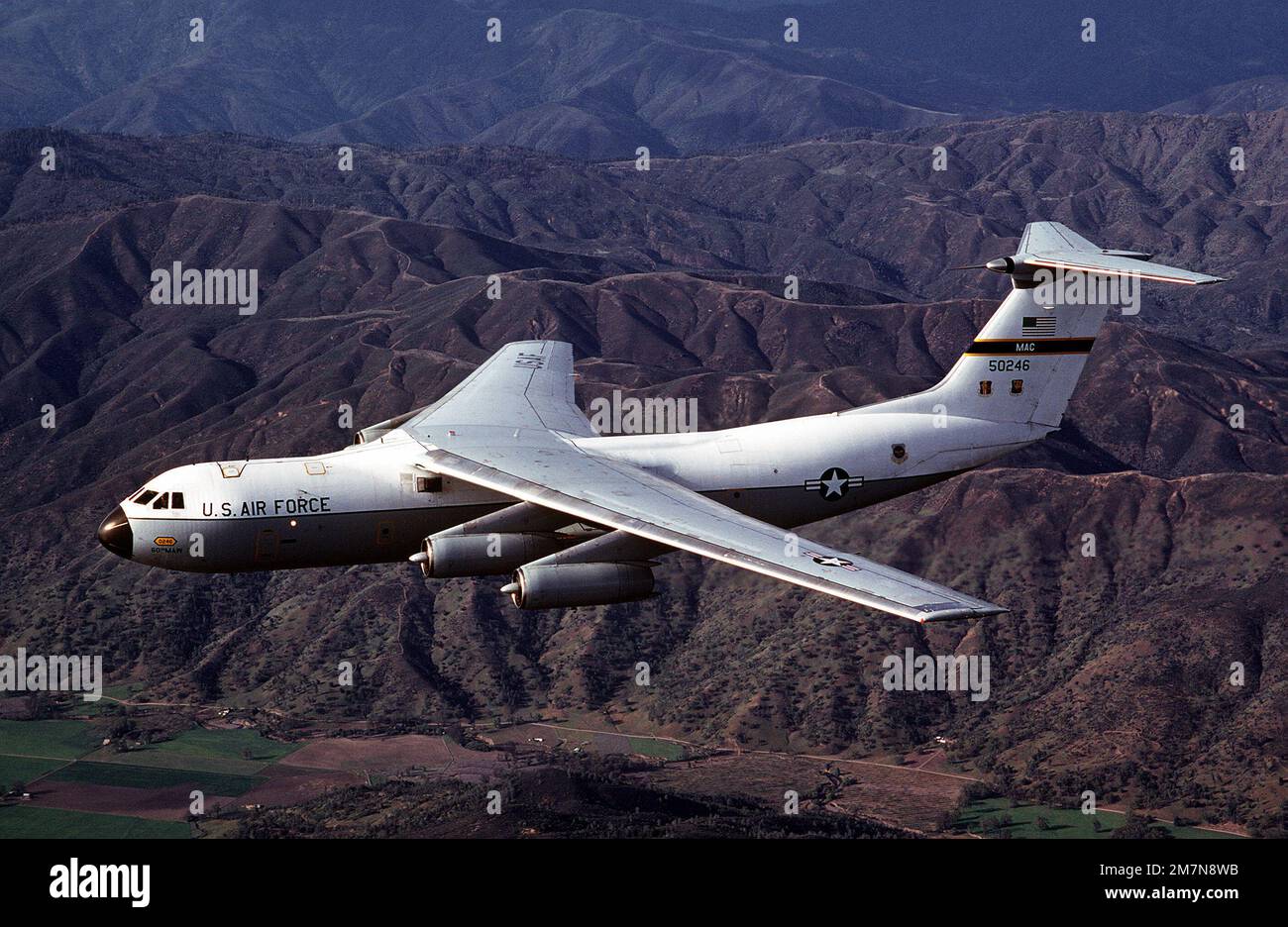 An air-to-air left side view of a C-141 Starlifter aircraft from the ...