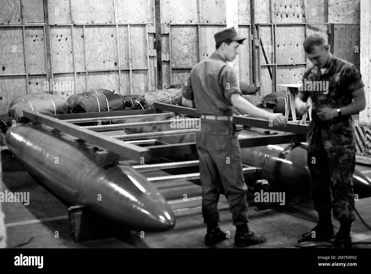 Two Marines from Headquarters Squadron 28 are preparing a raft for the ...