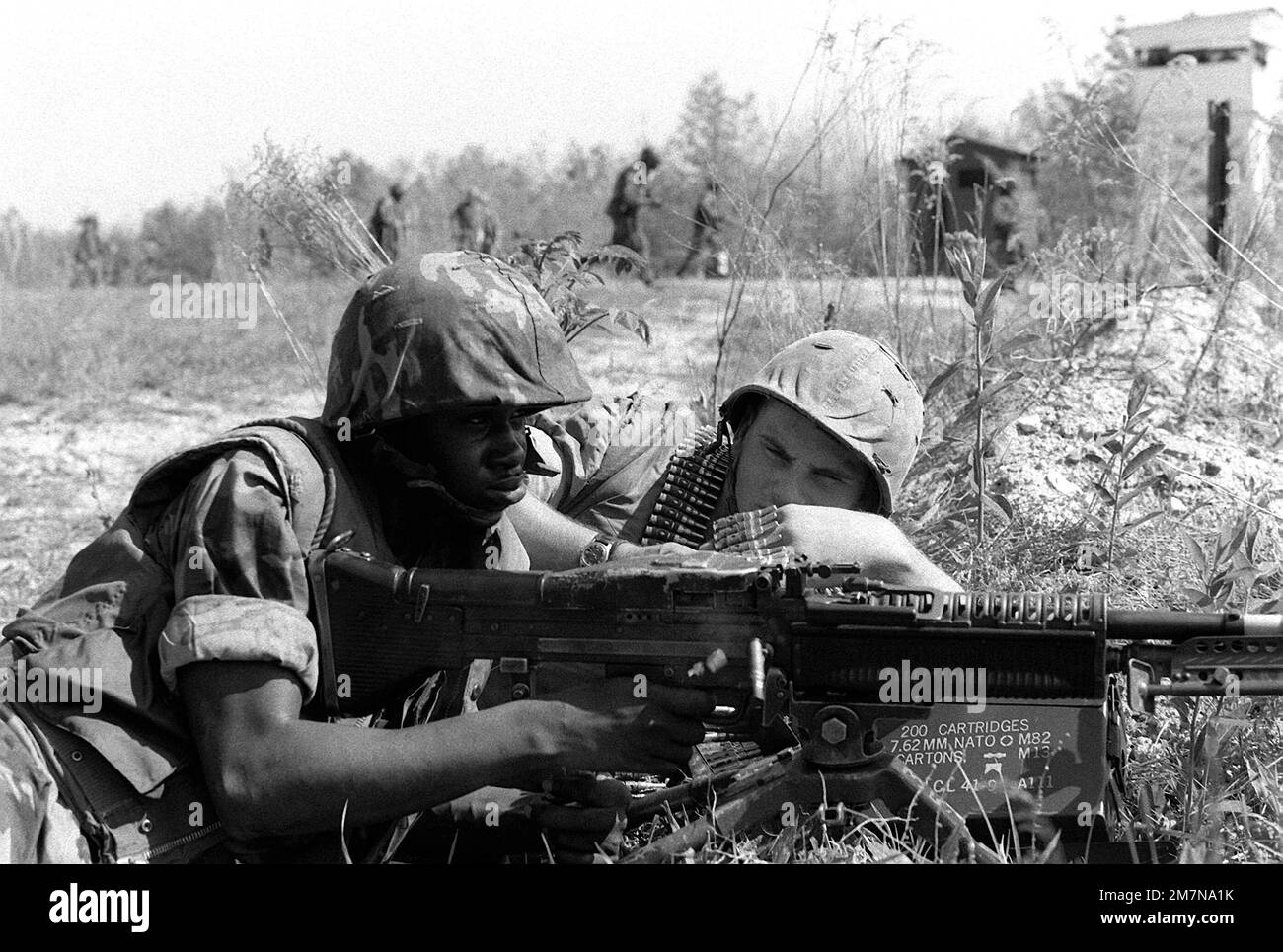 A Marine machine gunner and his assistant are in position to defend ...