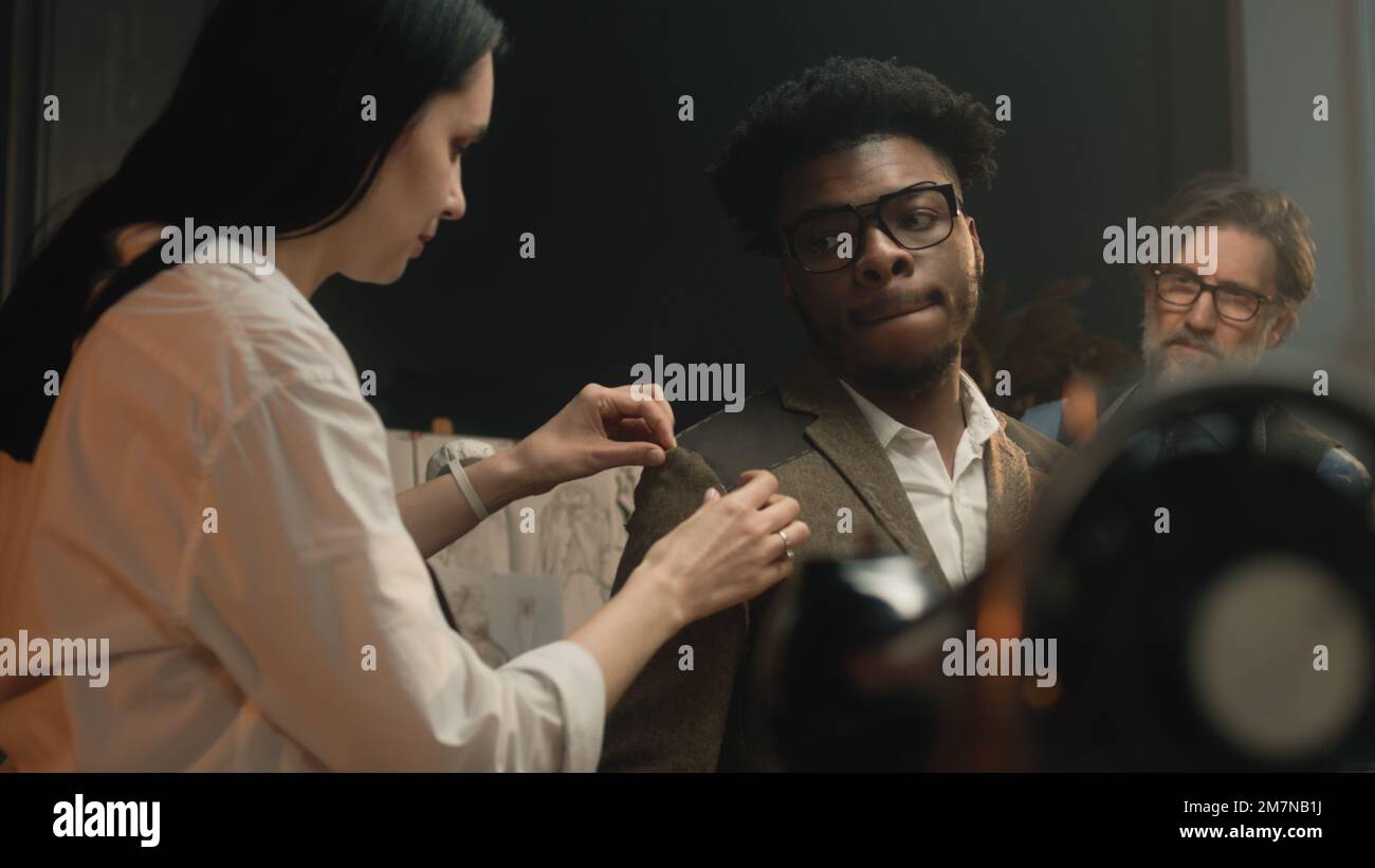Female tailor measures tailored suit, discusses with client size and ...