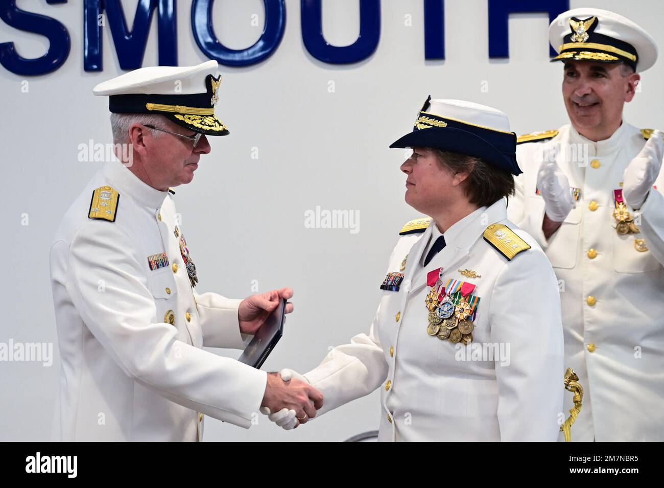 Vice Adm. Steven Poulin, Atlantic Area commander, shakes hands with Rear Adm. Laura Dickey ...