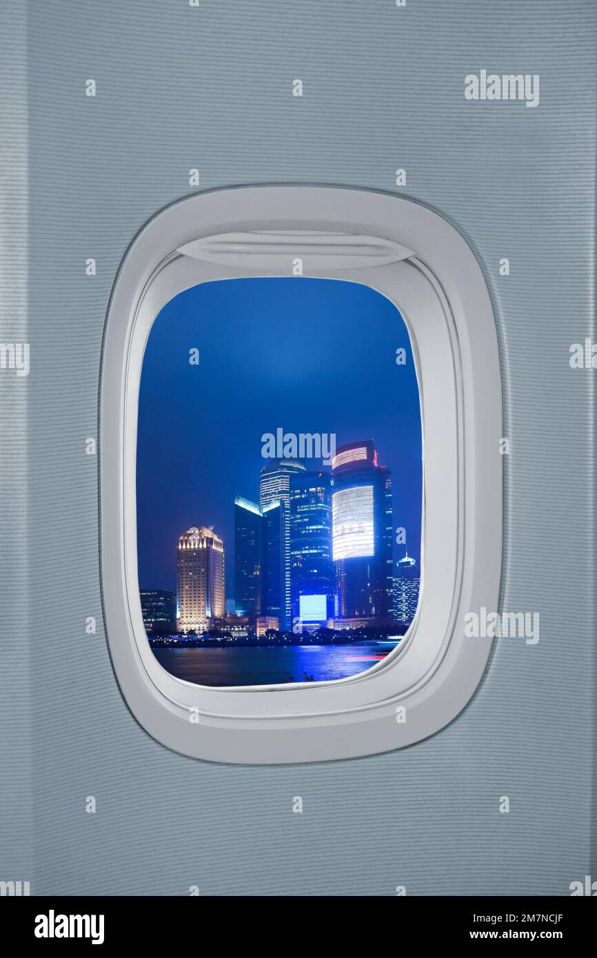 Airplane window with city skyline scene Stock Photo - Alamy