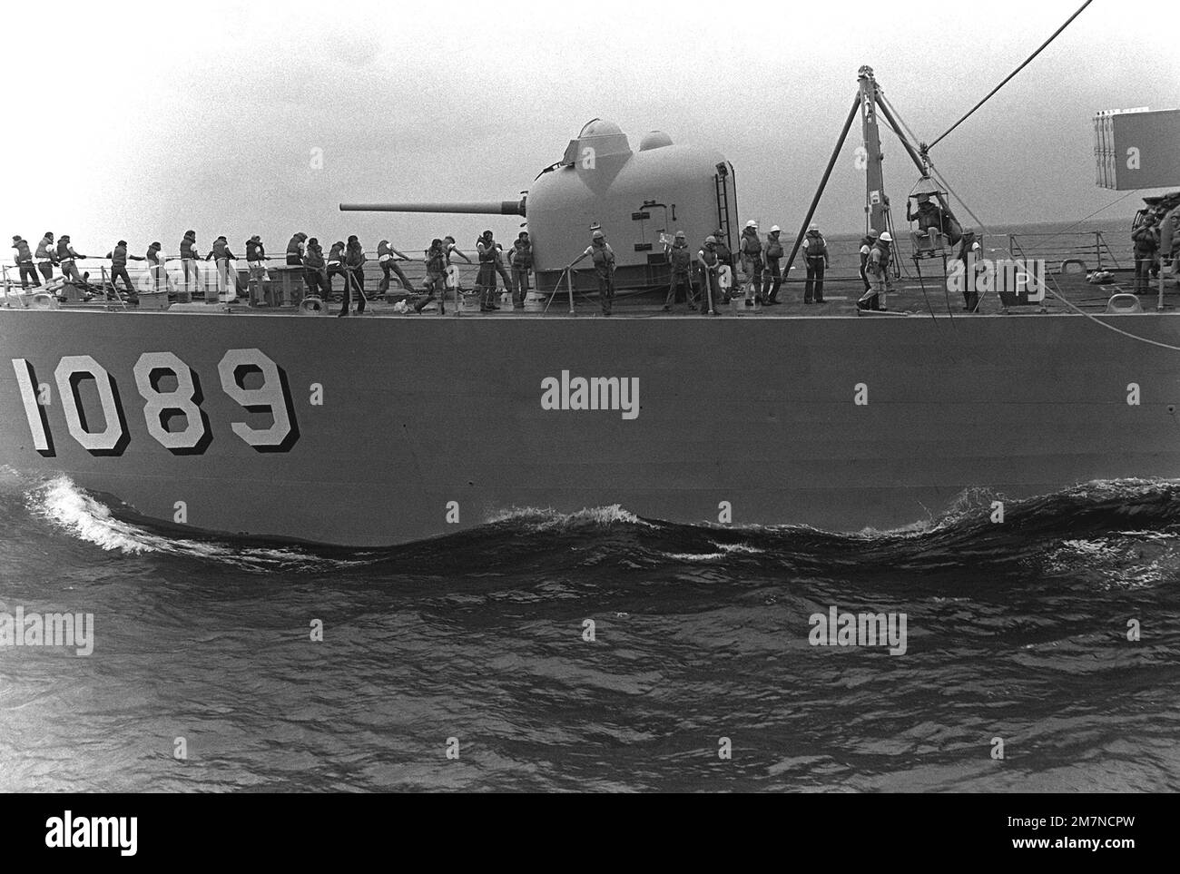 A crewman is transferred from the guided missile destroyer USS DEWEY ...