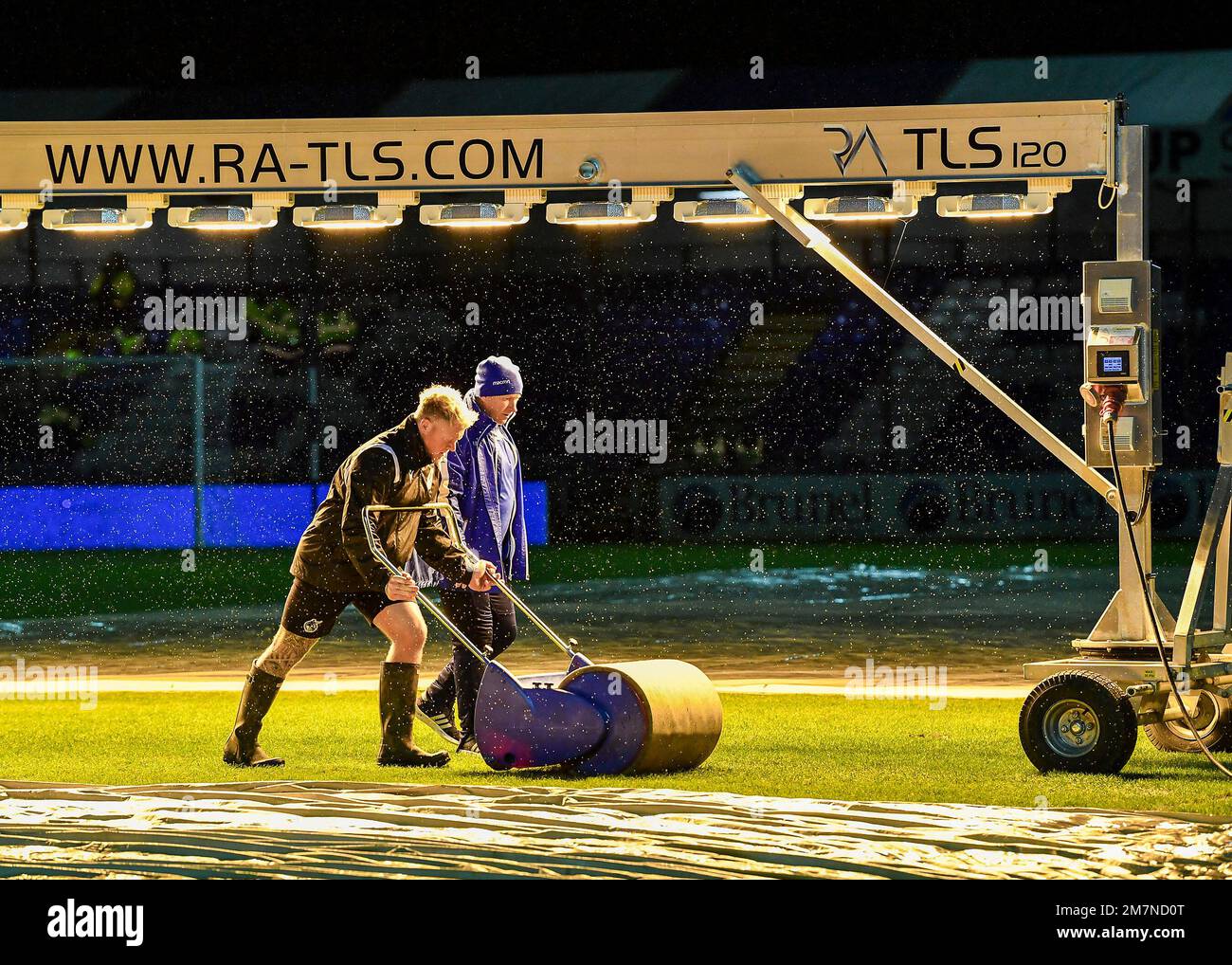 Groundsman of Bristol Rovers roller the pitch and trying to clear the ...