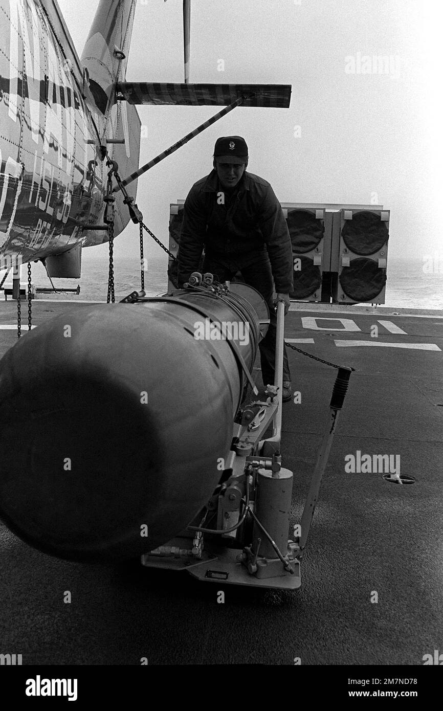A crewman aboard the frigate USS TRIPPE (FF-1075) loads a Mark 46 anti ...