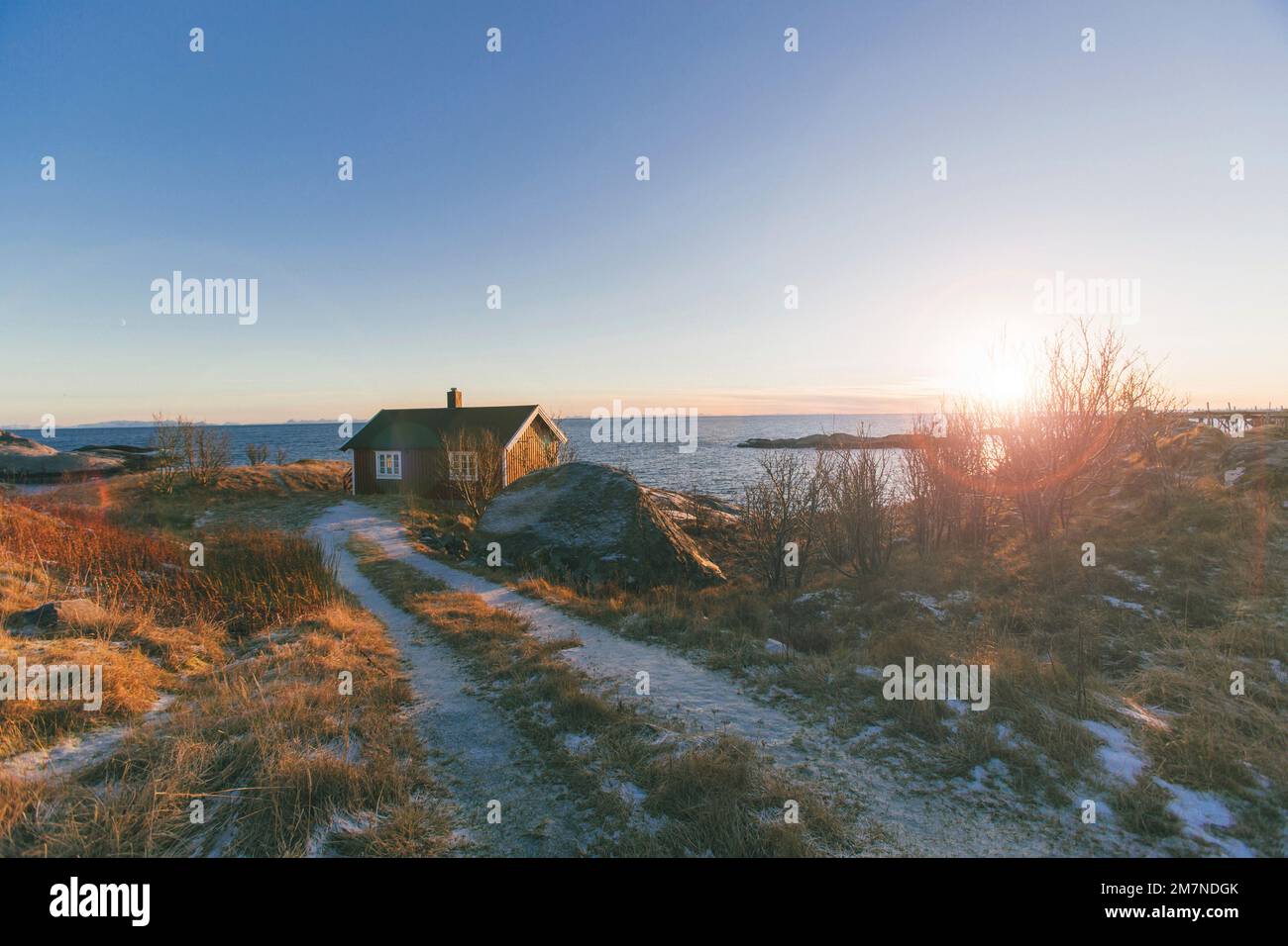 Traditional rorbu cabin / house in Lofoten, with access road at sunset ...