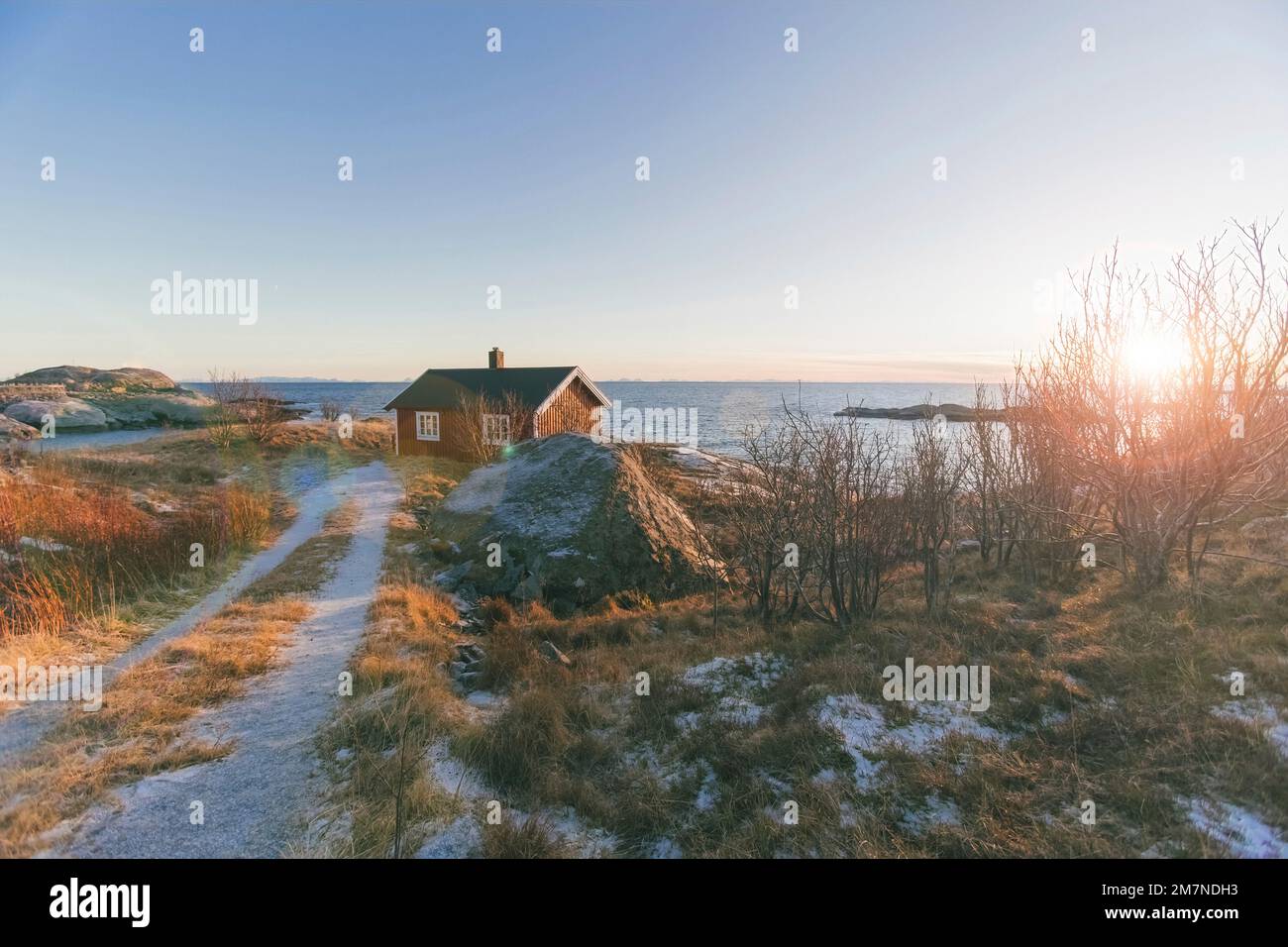 Traditional rorbu cabin / house in Lofoten, with access road at sunset ...