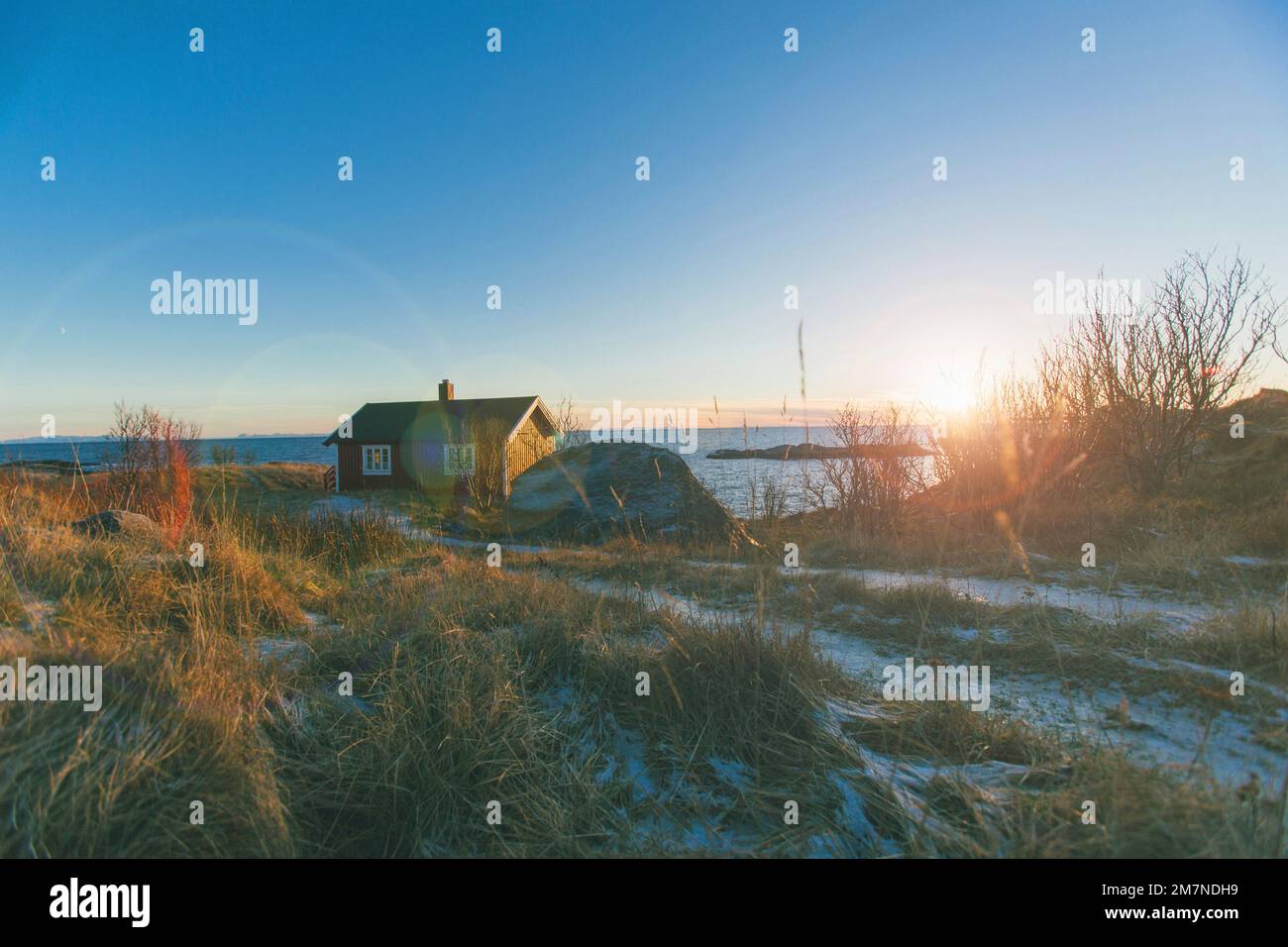 Traditional rorbu cabin / house in Lofoten, with access road at sunset ...