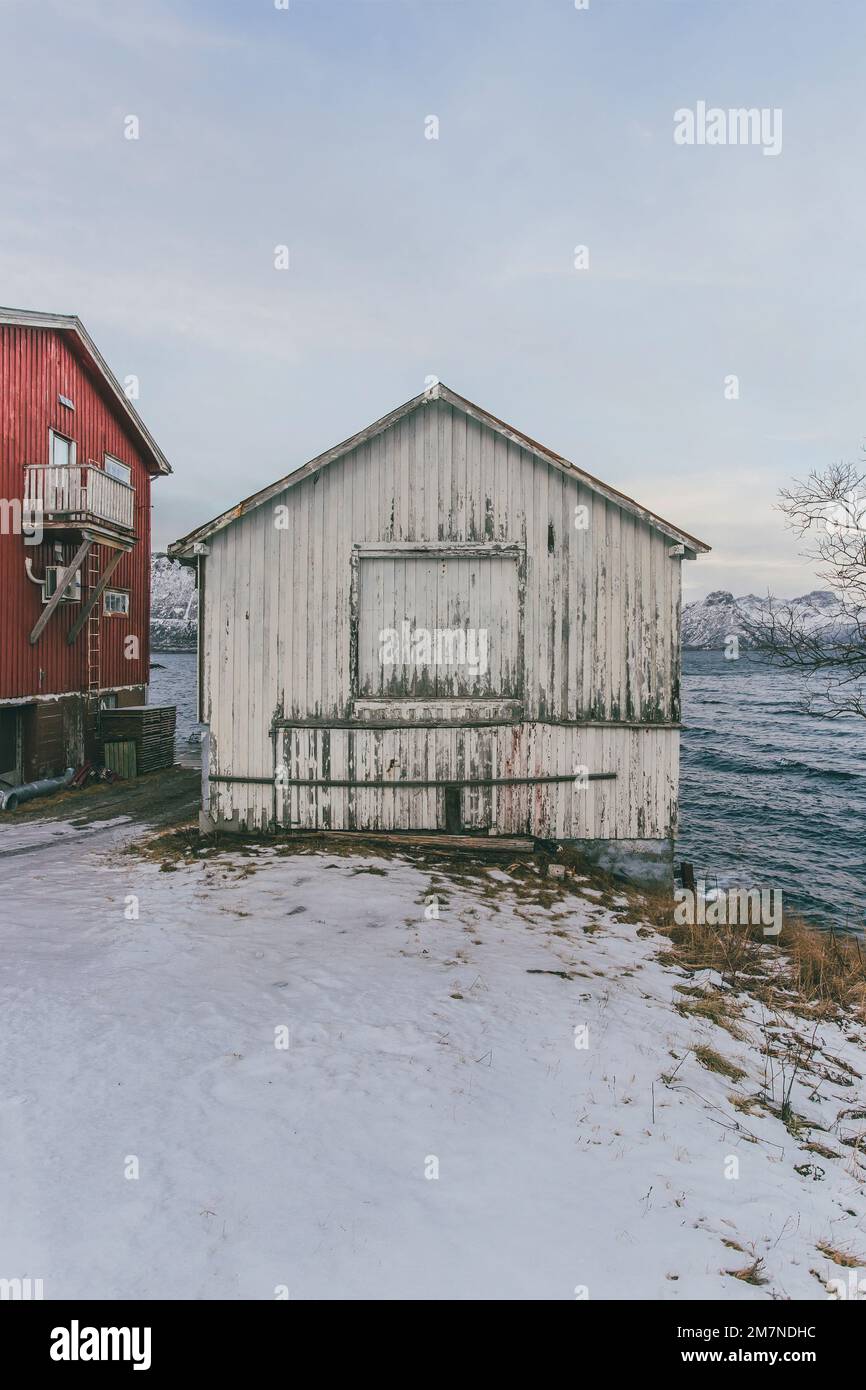 Old wooden boathouse, painted white, peeling paint of old building ...