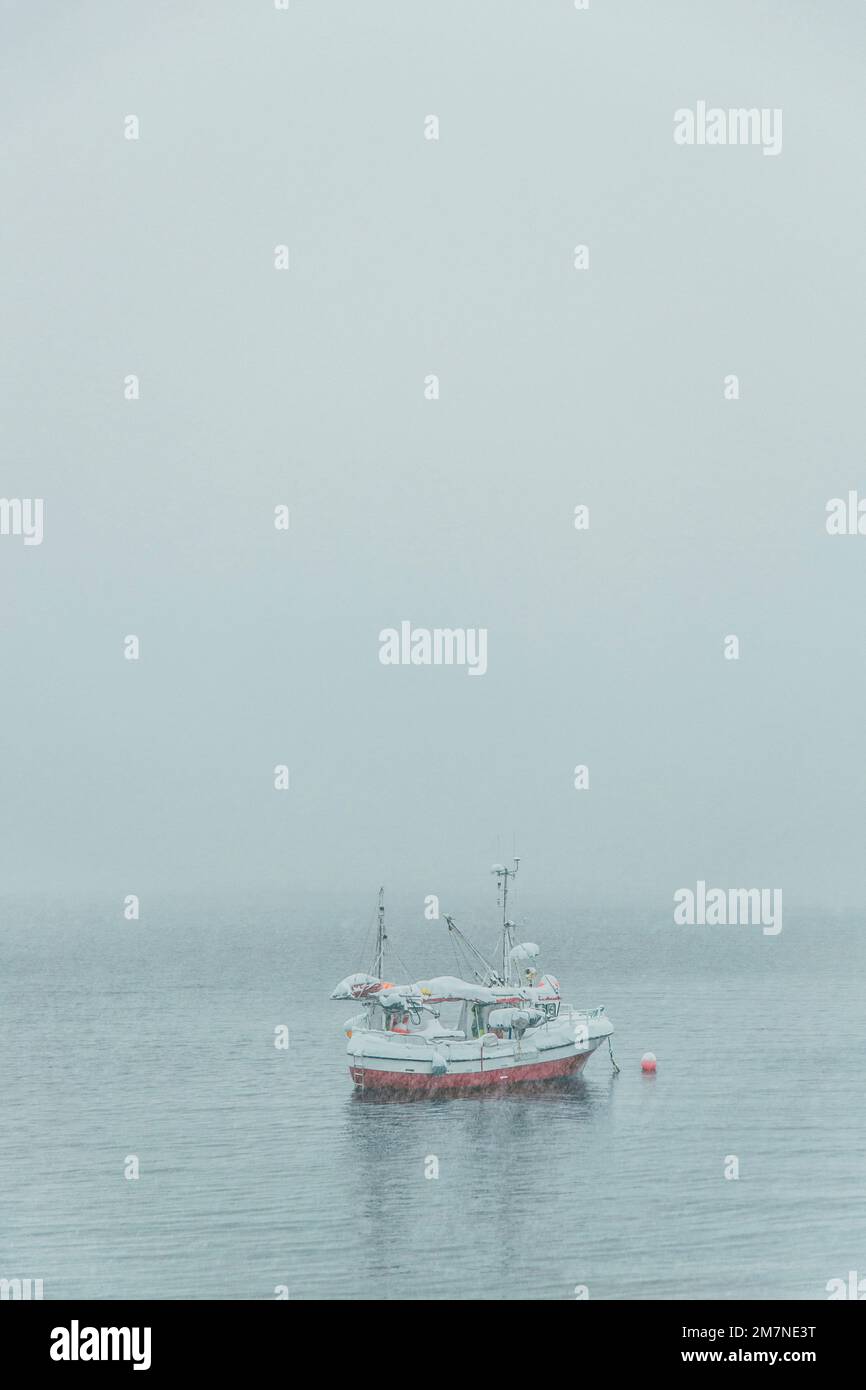 Red fishing boat in fog, boat in fjord in Norway, snow and ice ...