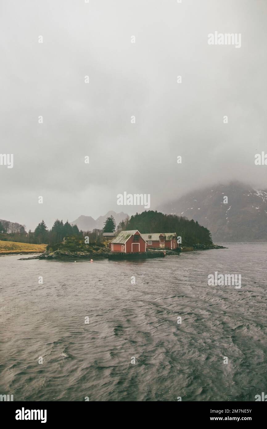 Three red lonely fishing huts on the fjord in Norway, typical fjord ...