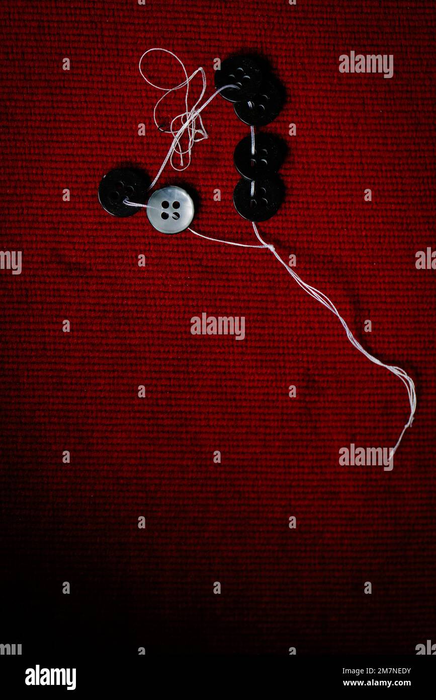 Black buttons strung on a white thread Stock Photo - Alamy