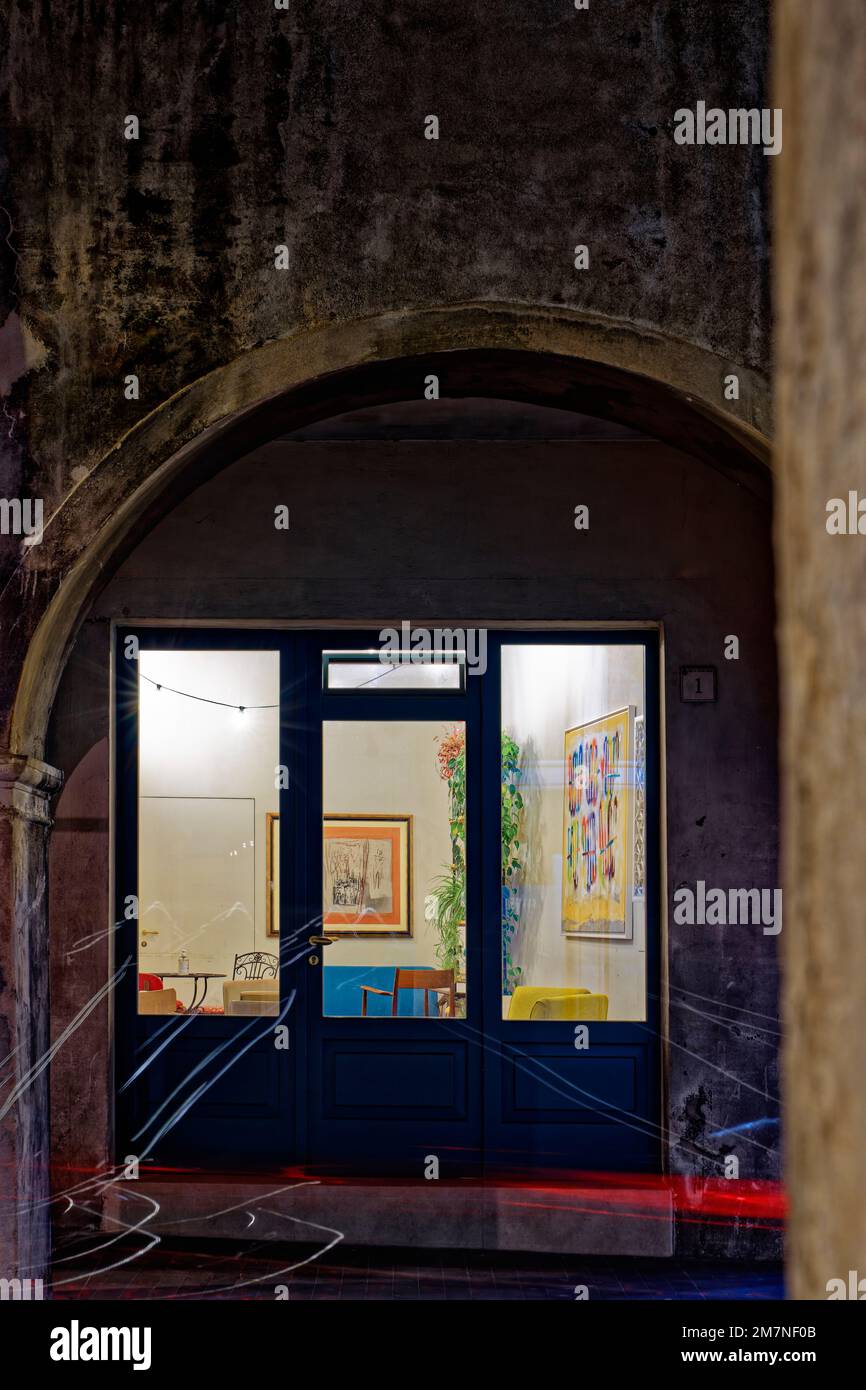 View of an illuminated shop window with furniture and pictures in the ...