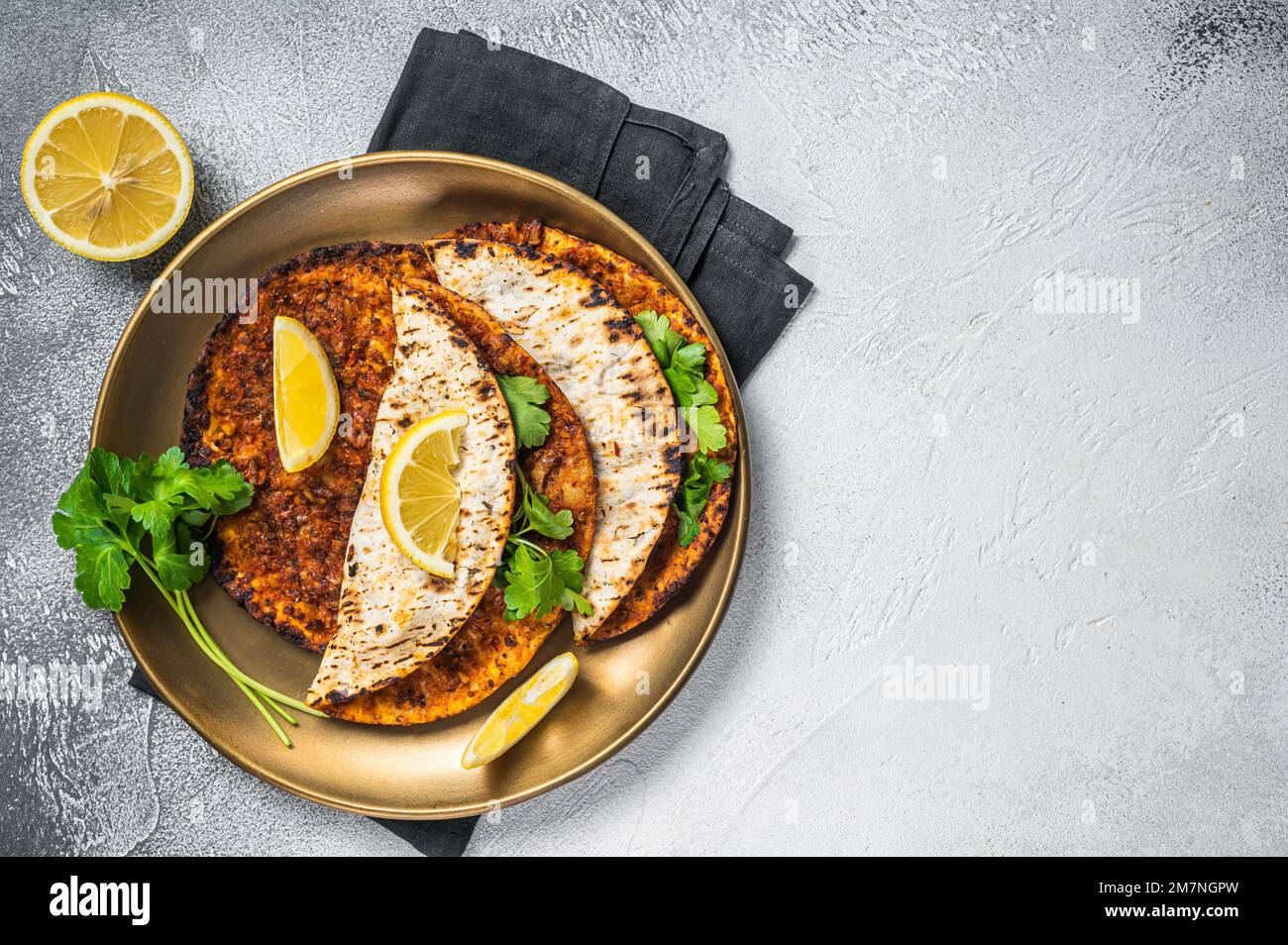 Turkish lahmacun pizza with mince meat and tomatoes on a plate with ...