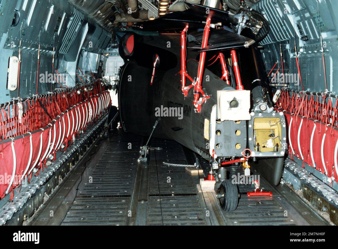 A UH-60A Black Hawk helicopter is loaded into a C-141 Starlifter ...