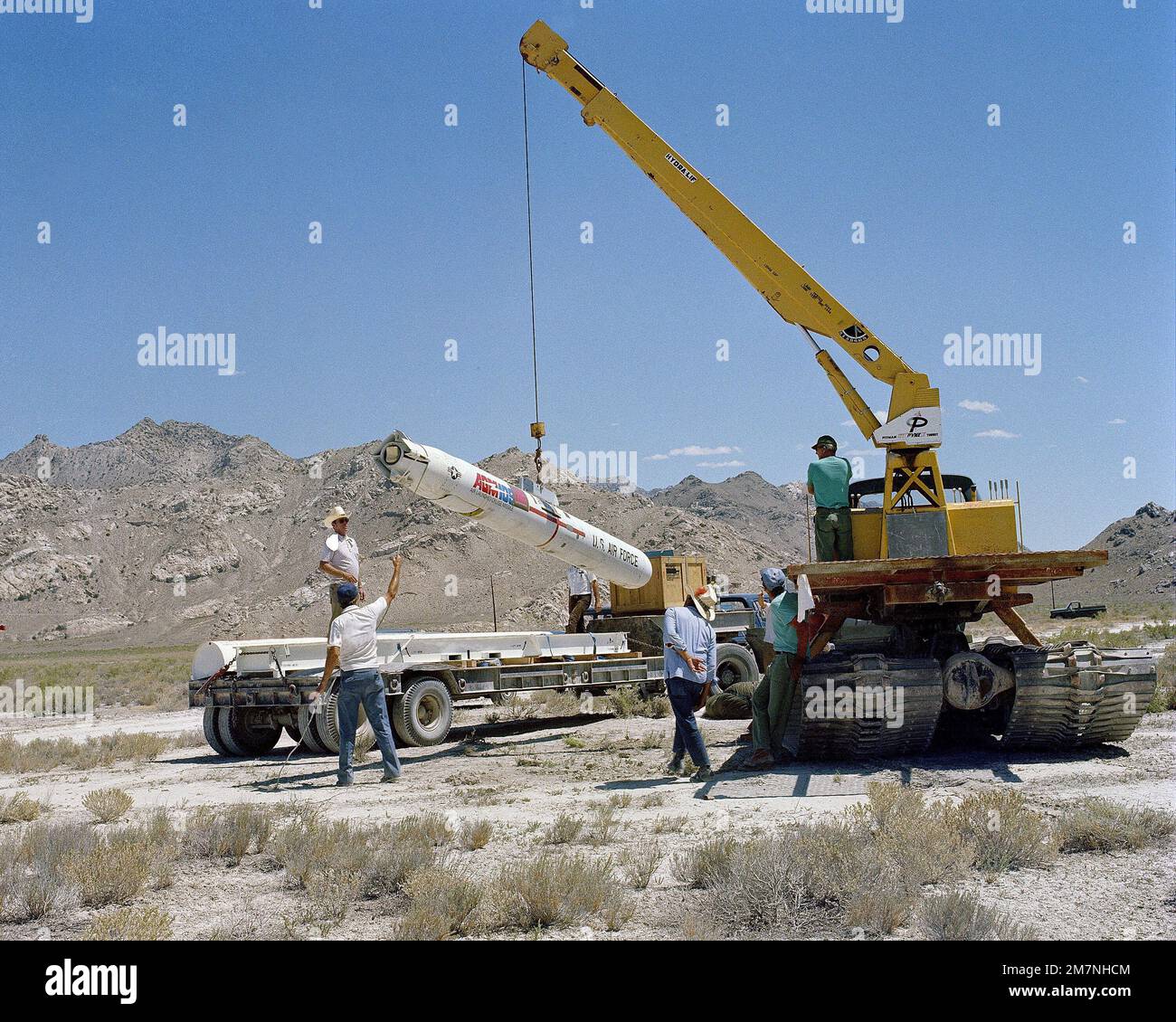 A ground crew uses a tracked wrecker to lift an AGM-109 Tomahawk air ...