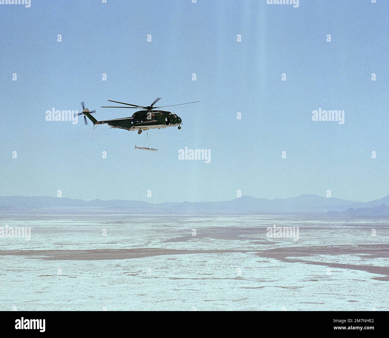 A right side view of a CH-53 Super Jolly helicopter airlifting an AGM ...
