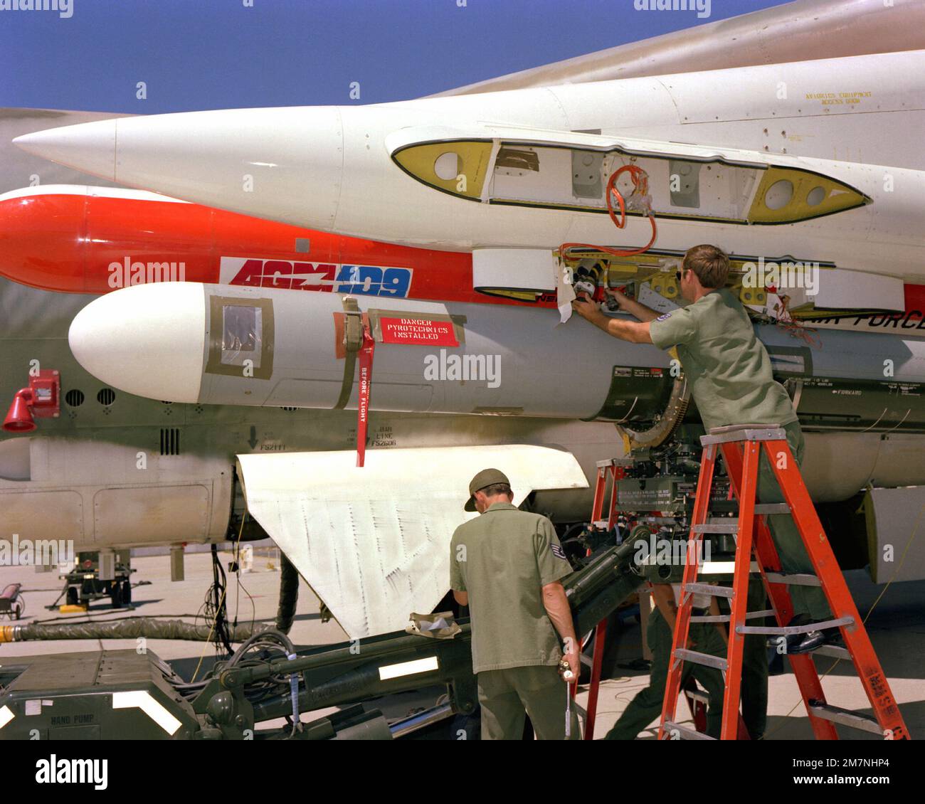 A ground crew loads AGM-109 Tomahawk air-launched cruise missiles on a ...