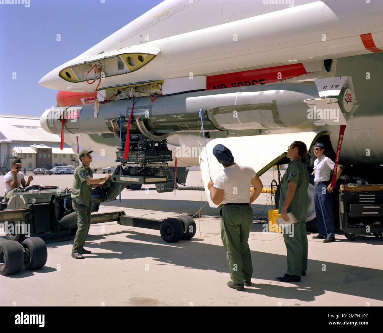 A ground crew loads an AGM-109 Tomahawk air-launched cruise missile on ...