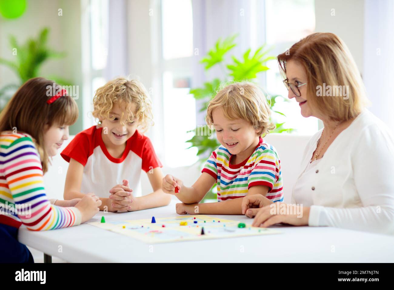 Family playing board game at home. Kids play strategic game. Little boy ...