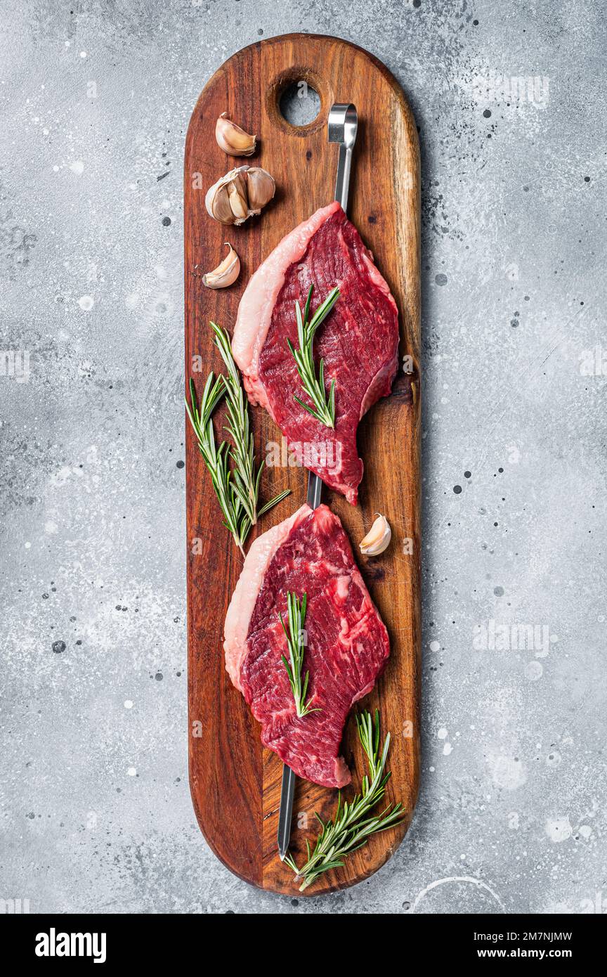 Raw Picanha Brazilian Grilling Steaks with herbs and spices. Gray ...