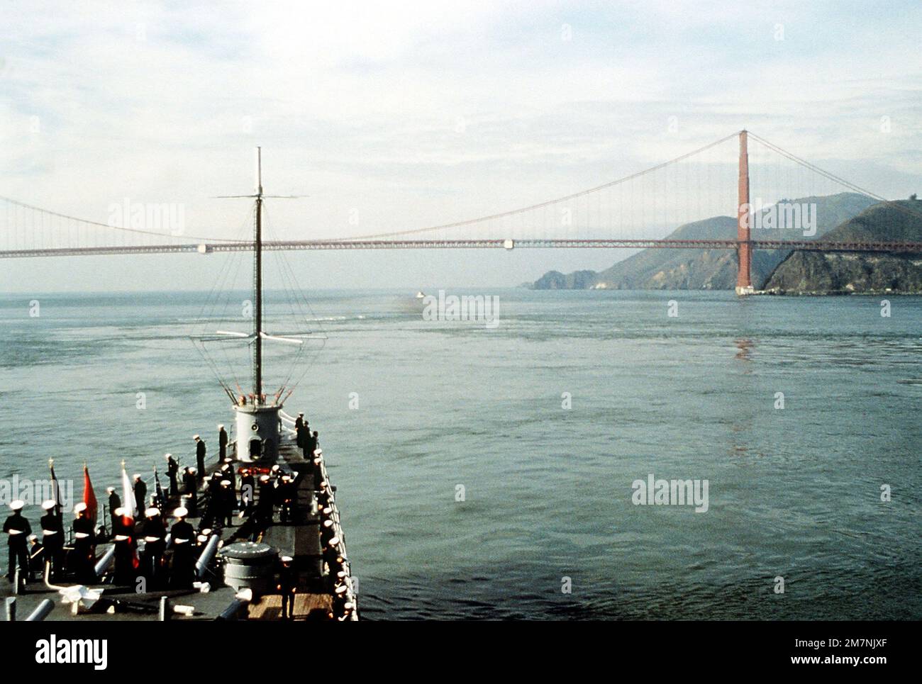 Crewmen line the rails and a Marine honor guard stands atop the six ...